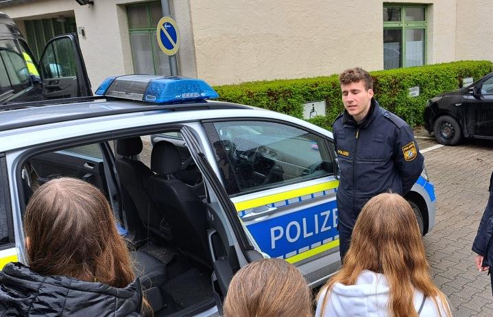 Junge Beamte in Ausbildung führen Achtklässlerinnen durch die ...